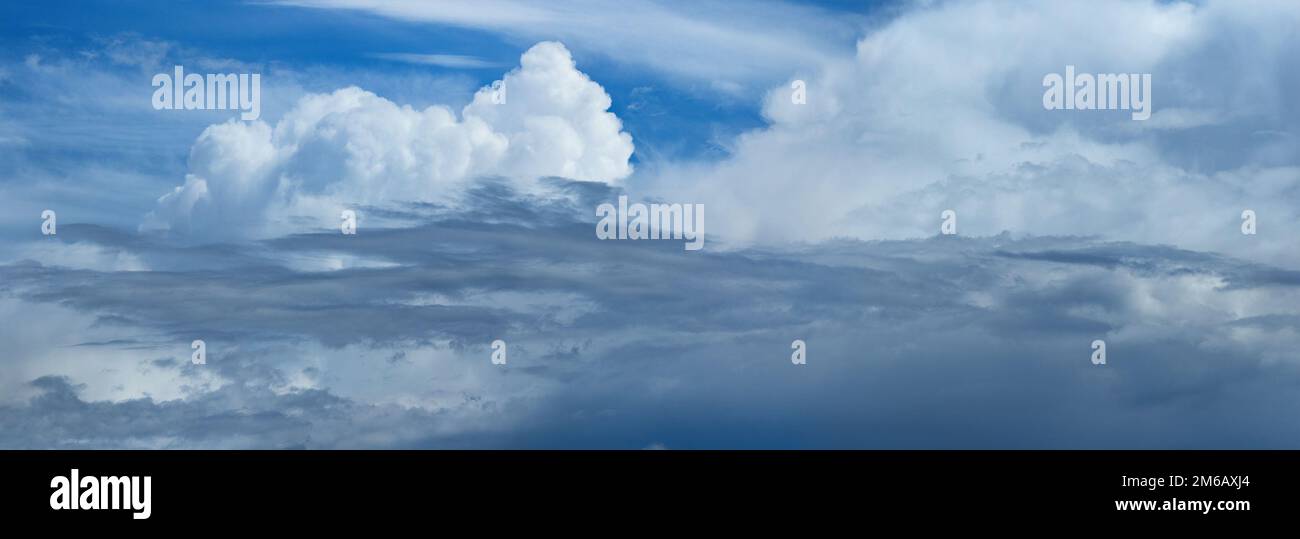 Panoramic photo of blue sky with white cumulus clouds. First stage of a ...