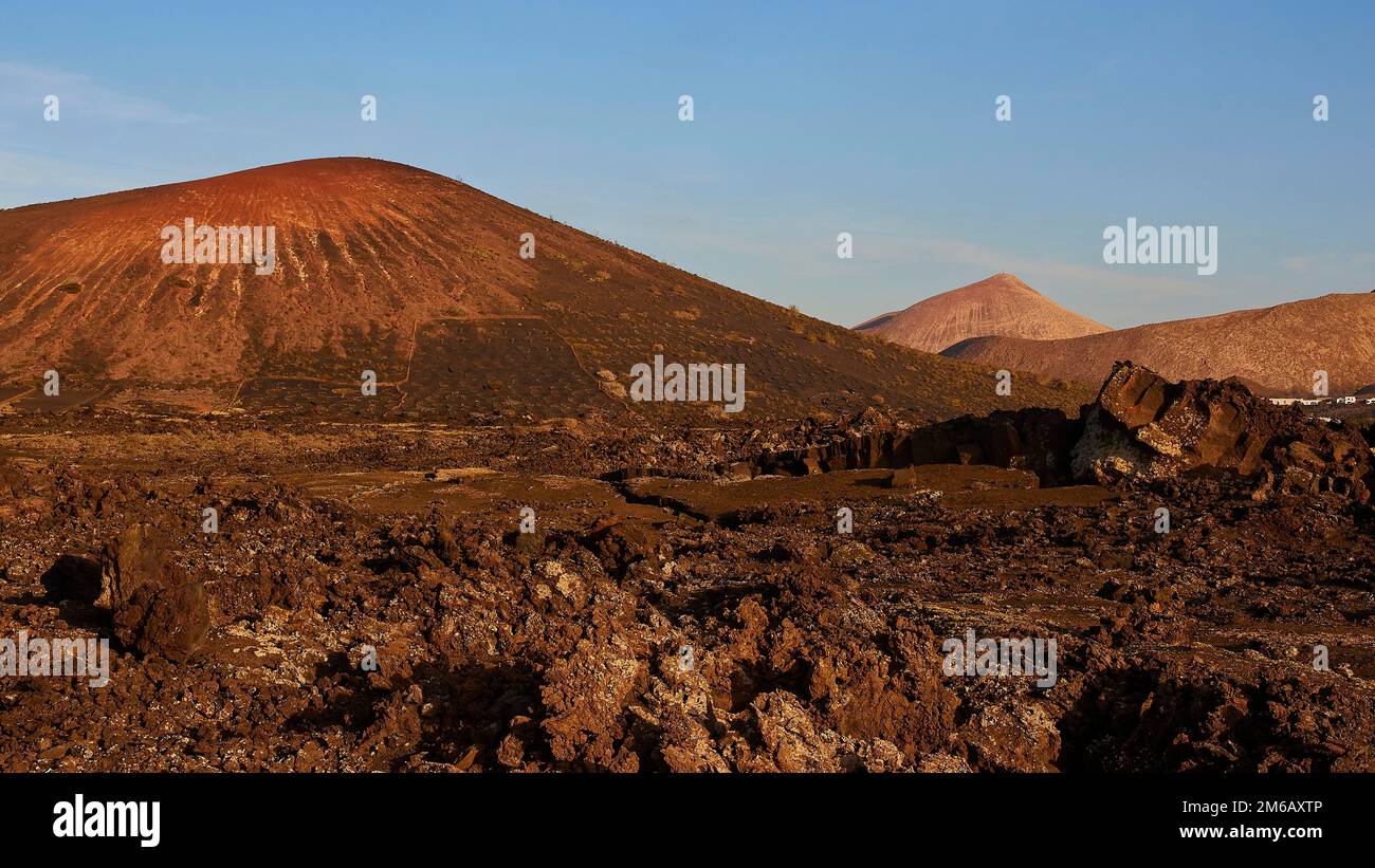 Los Vulcanos, lava landscapes with isolated volcanoes, red-brown earth ...