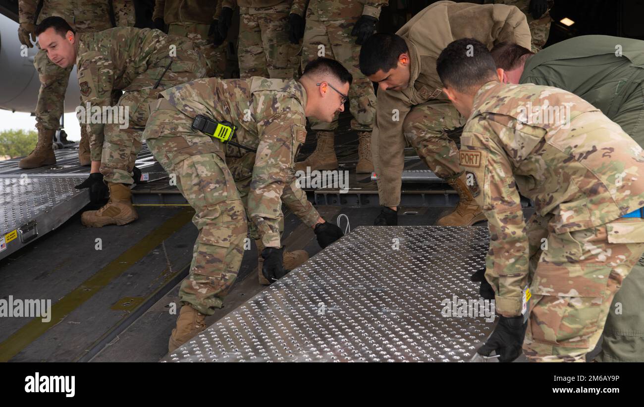 Airmen assigned to the 89th Aerial Port Squadron put ramps in place to ...
