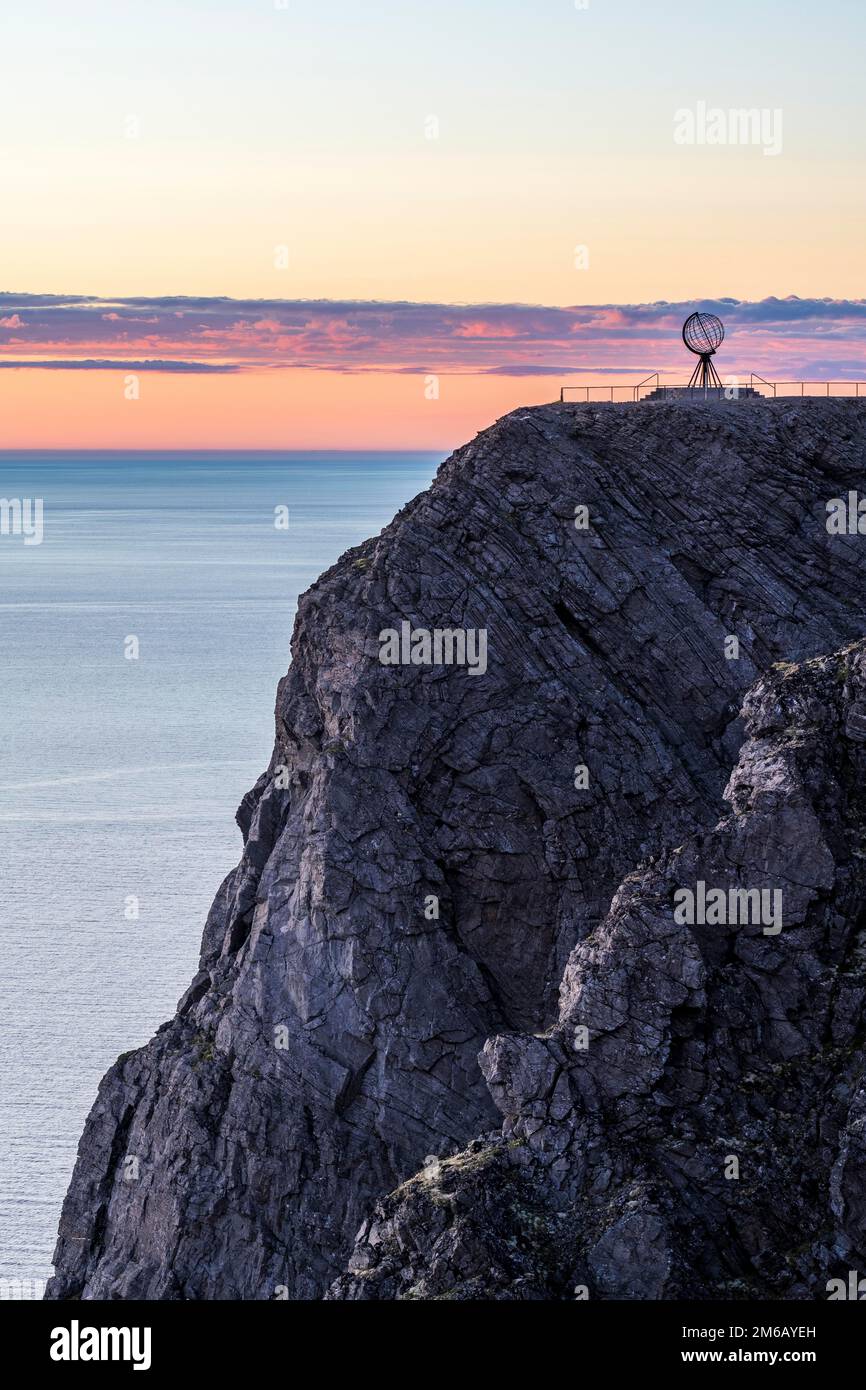 Rock cliff of the North Cape with steel globe at midnight sun, Nordkapp ...