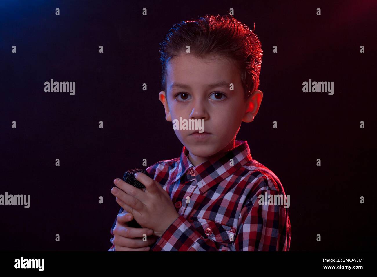 Boy in party lights with microphone Stock Photo - Alamy