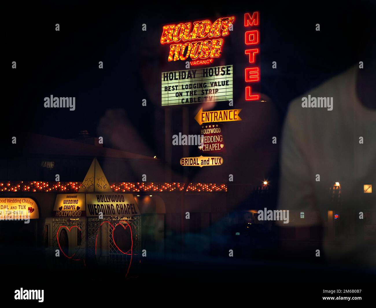 View from bus of neon lights and two hearts, neon sign for hotel and ...