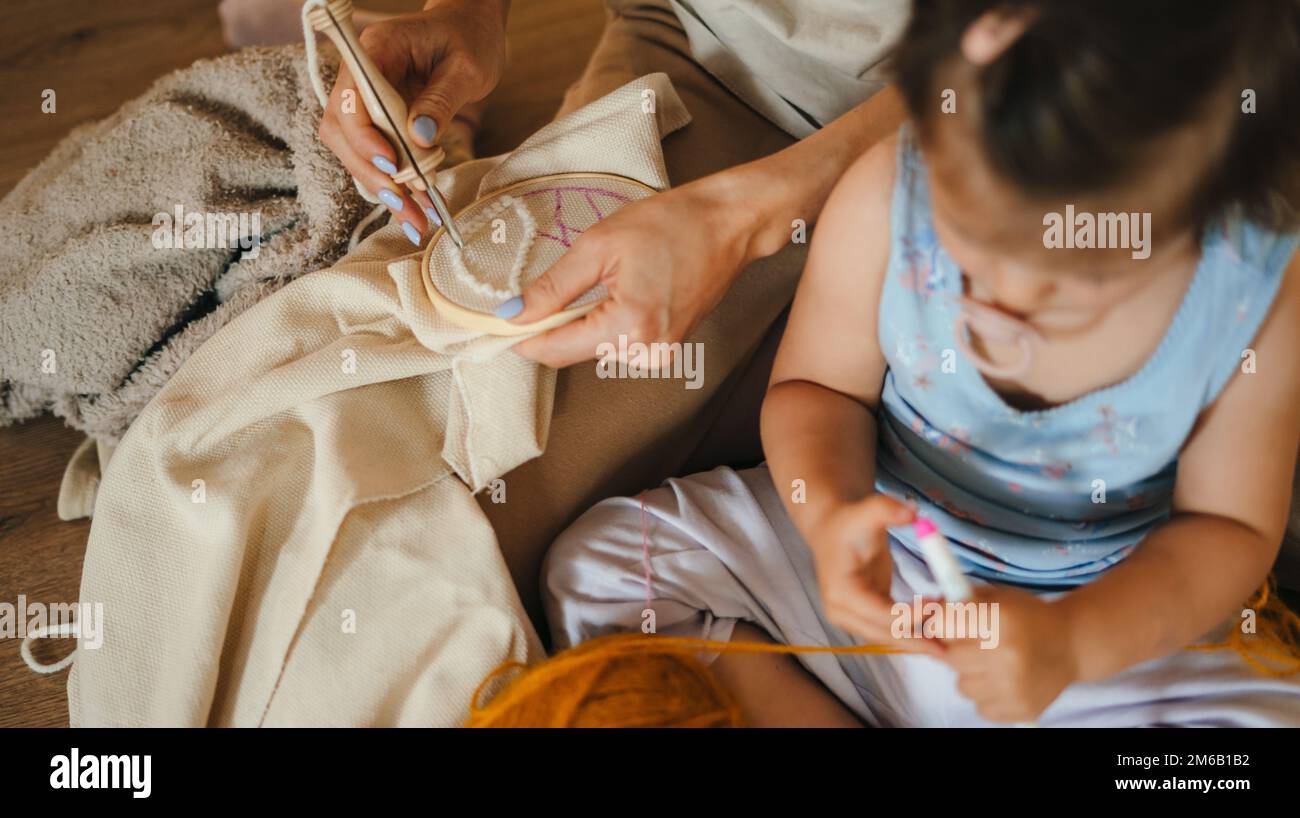 Mother teaching daughter girl knit, sewing accessories. Many object for ...