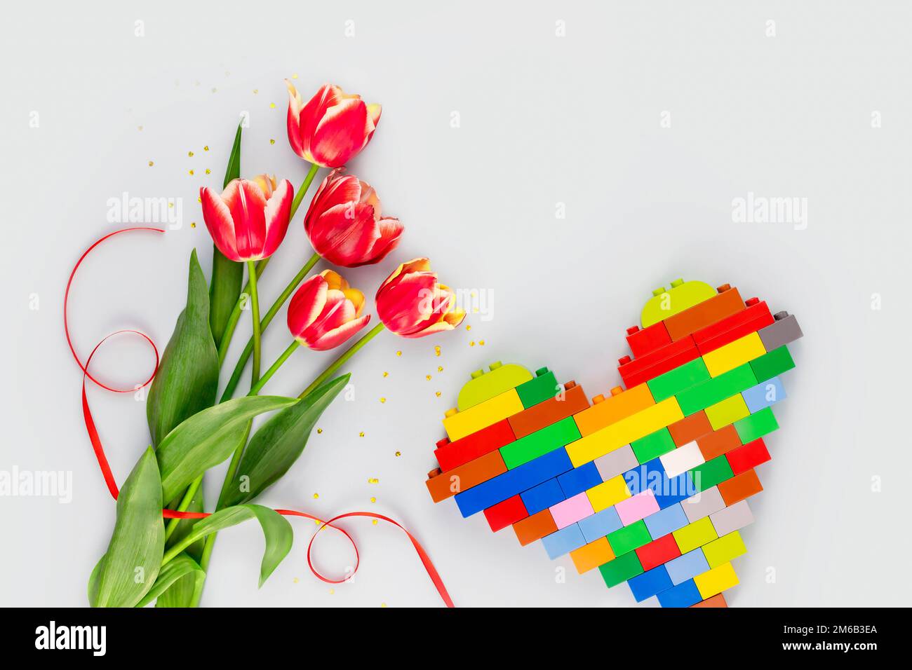 Holiday card with bouquet with red tulips and hande made bricks heart ...