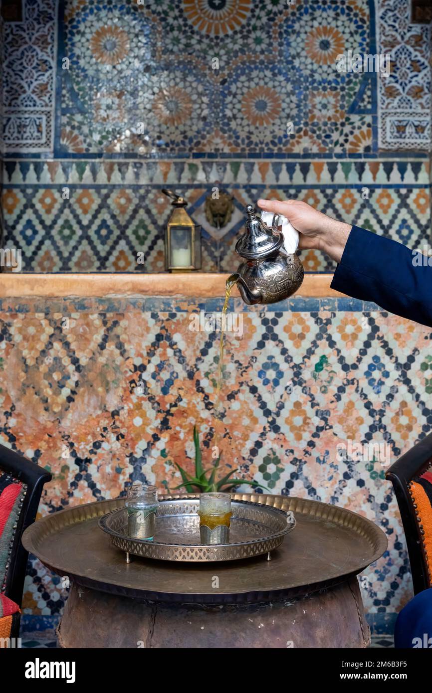 Moroccan serving mint tea in the traditional way, Marrakech Stock Photo ...