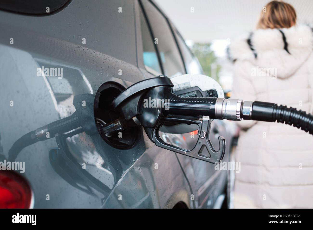 Woman pumping gasoline fuel in car at gas station. Petrol or gasoline ...