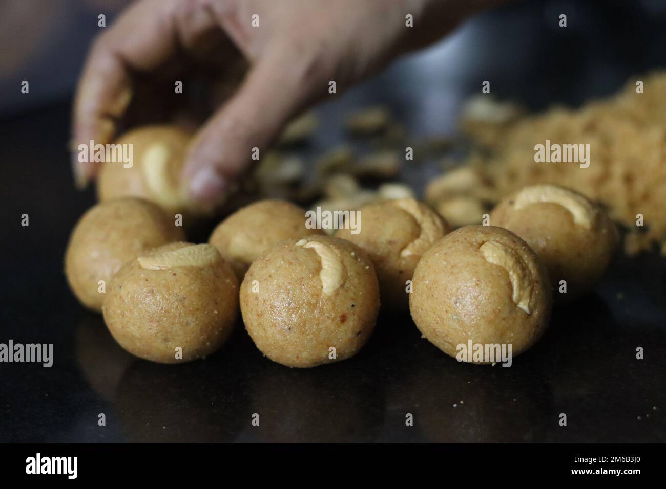 Preparation of moong dal laddu in a ball form with hand. It is a ...