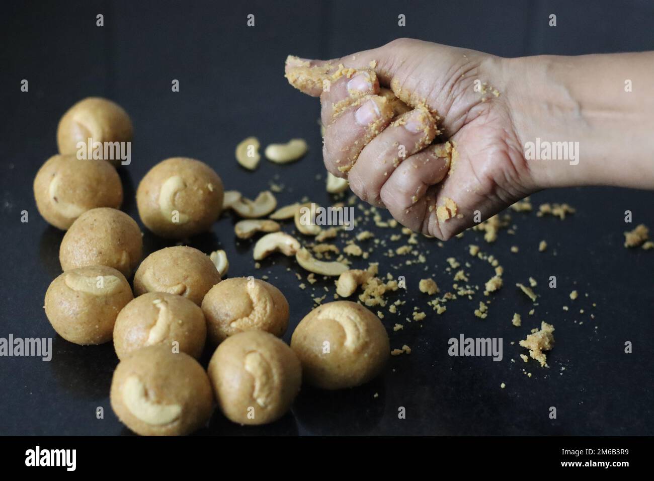 Preparation of moong dal laddu in a ball form with hand. It is a ...