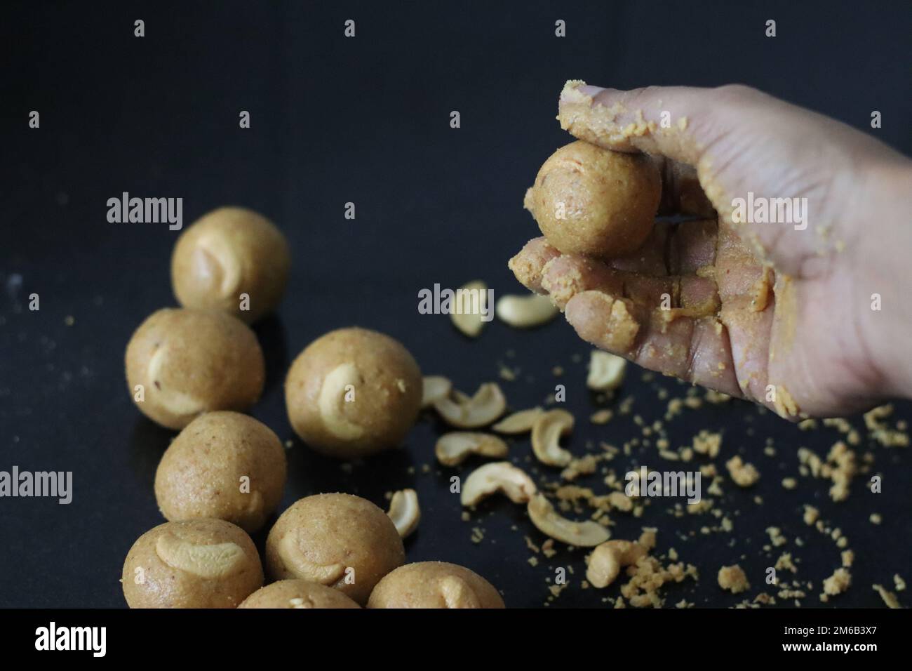 Preparation of moong dal laddu in a ball form with hand. It is a ...
