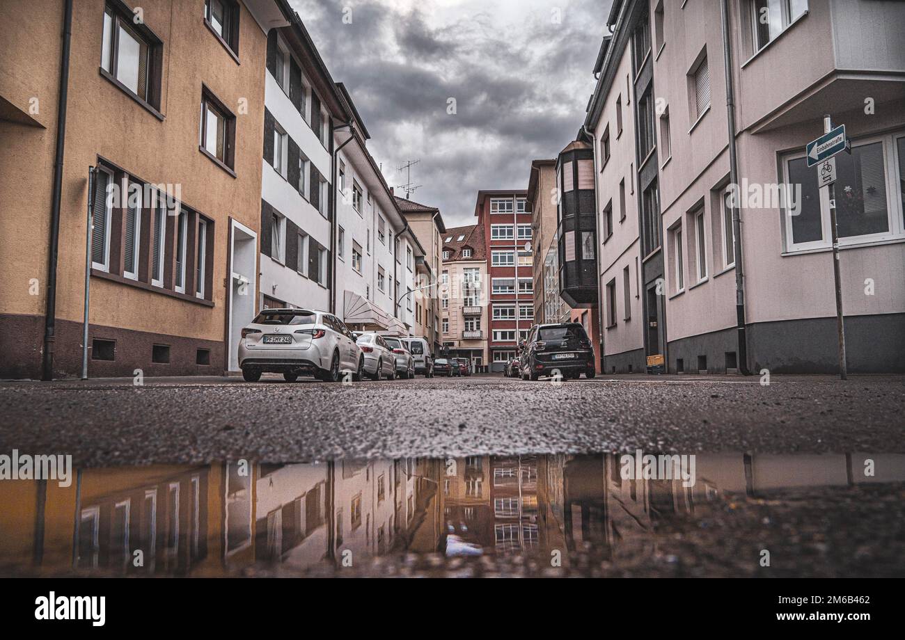 Gloomy atmosphere after rain in the city centre, reflection in puddle ...