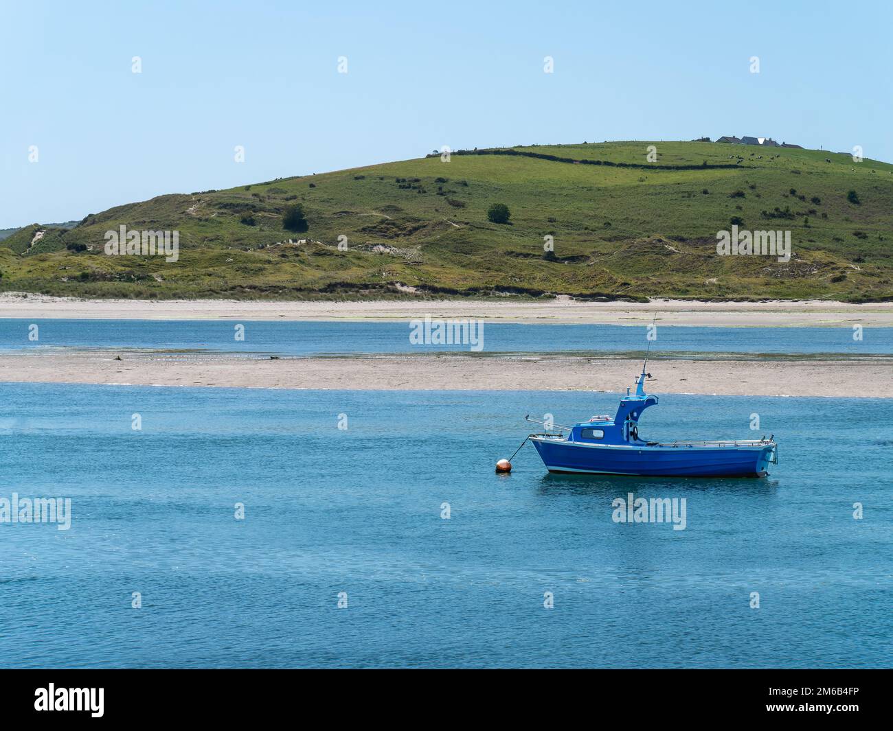 One small boat is anchored in the bay at low tide, a seaside landscape ...