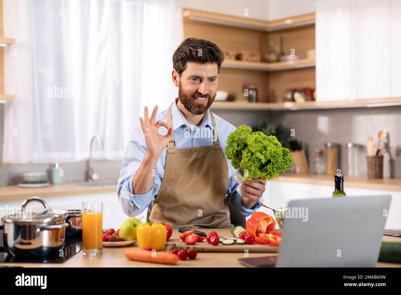 Glad millennial caucasian male cooking eat show salad and ok hand sign ...