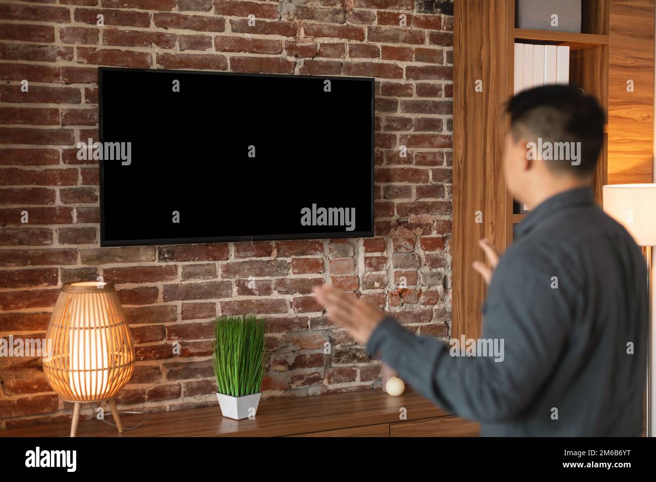 Surprised worried sad cheerful mature asian male watching tv with blank ...