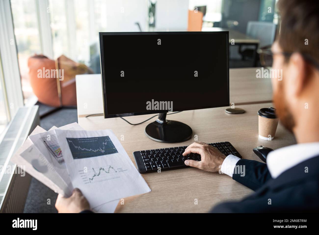 Unrecognizable male employee using computer with blank screen and ...