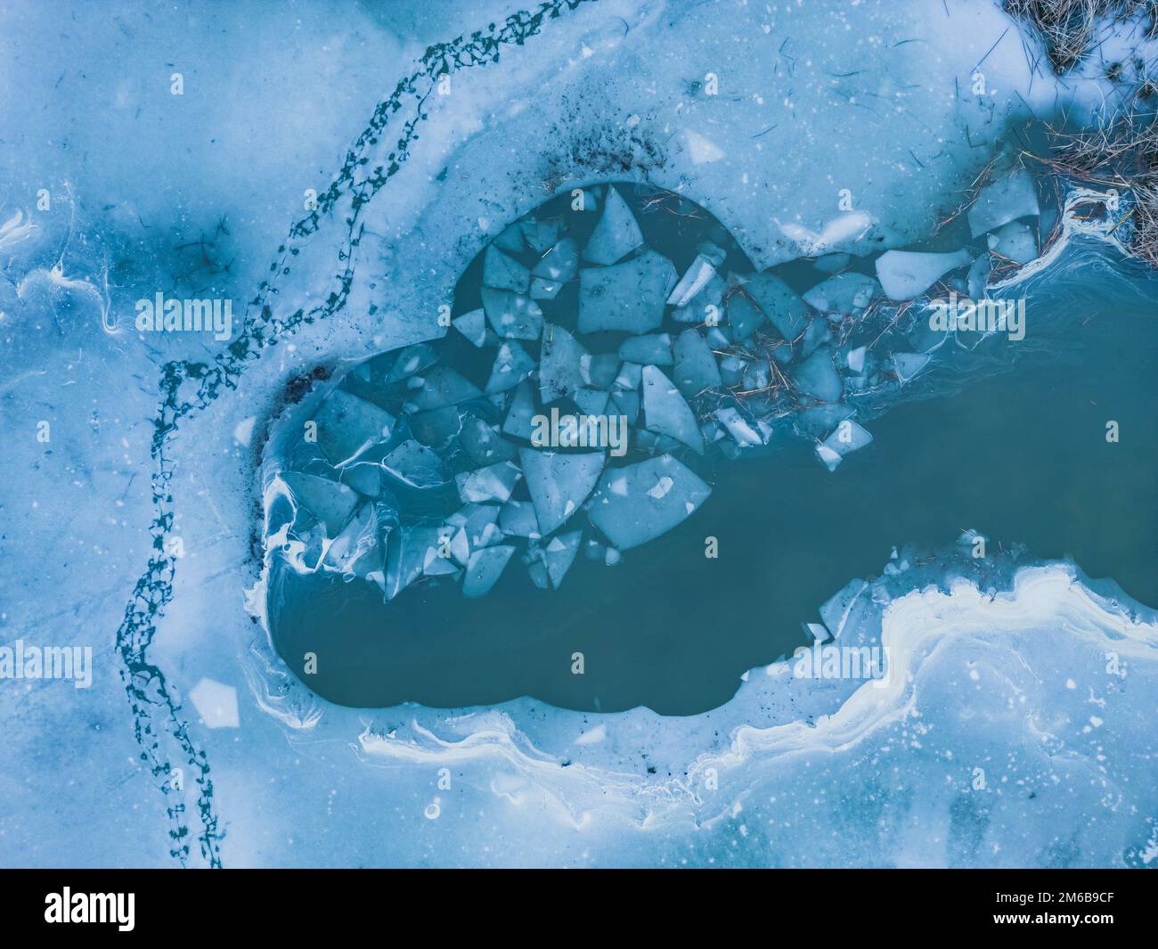 Panoramic aerial view of a frozen lake with animal tracks and cracked ...