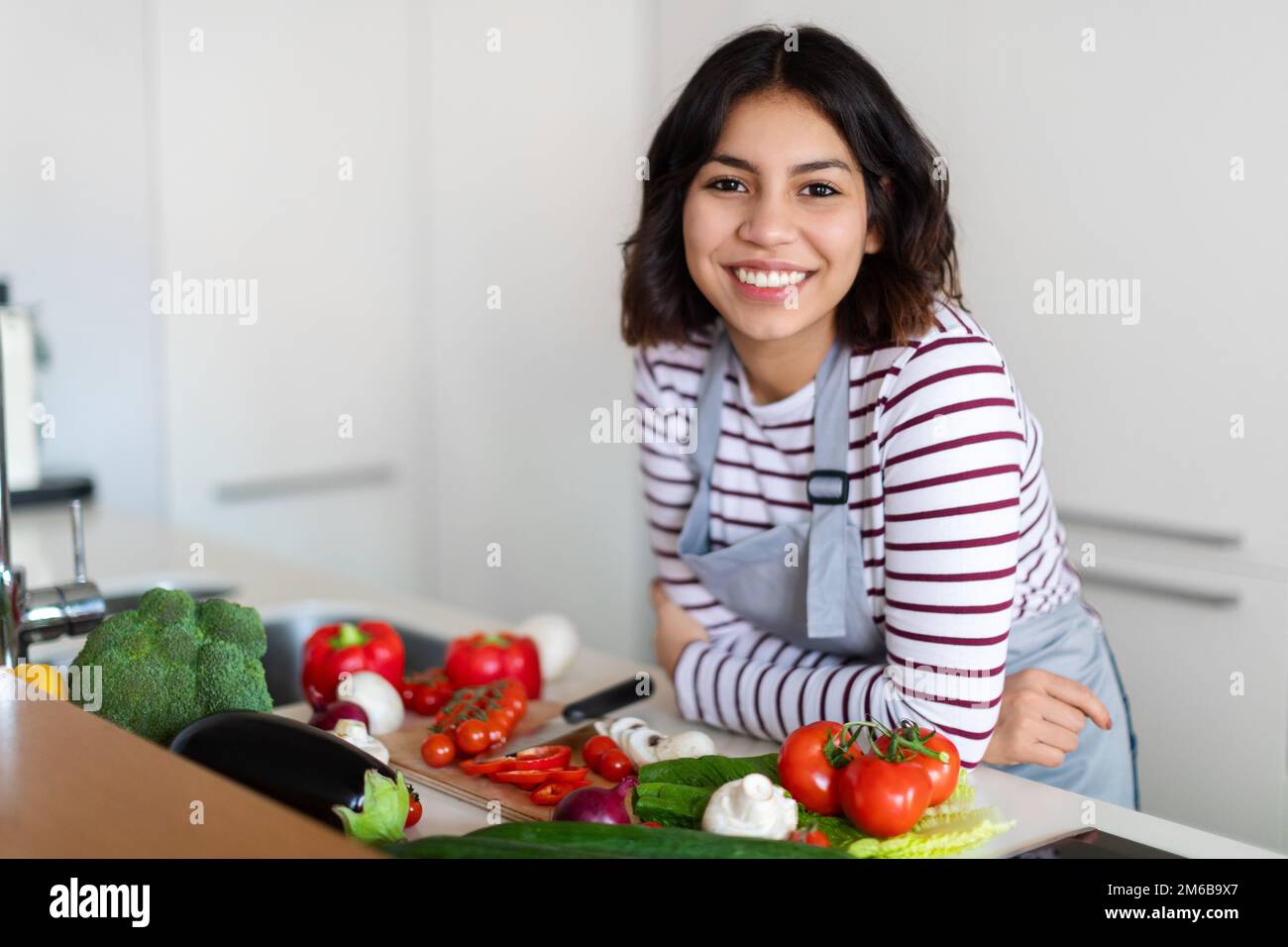 Portrait of attractive young woman chef posing at cozy kitchen Stock ...