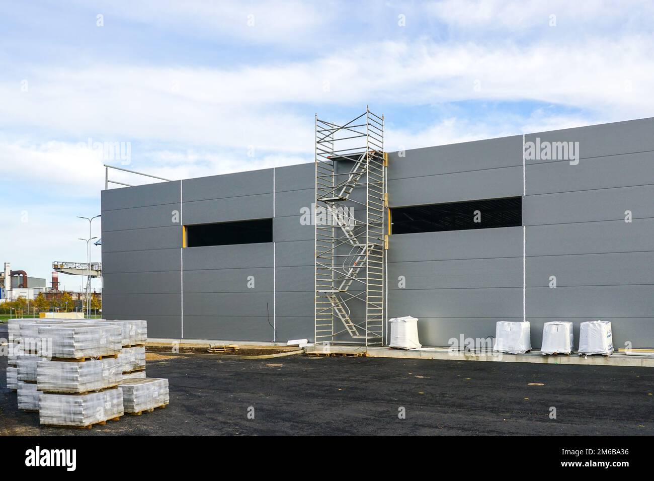 Gray sandwich panel facade of a unfinished warehouse building, tubular ...