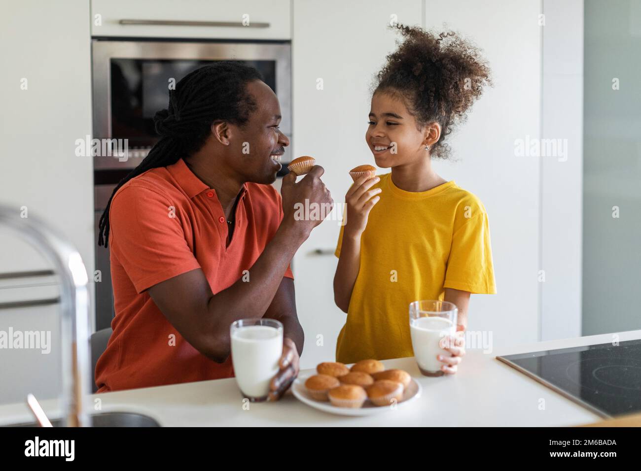 Portrait Of Cute Preteen Black Girl Eating Snacks With Dad In Kitchen ...