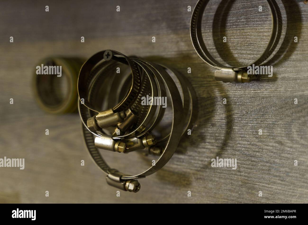 On the wall in the garage, metal clamps hang on self-tapping screws ...