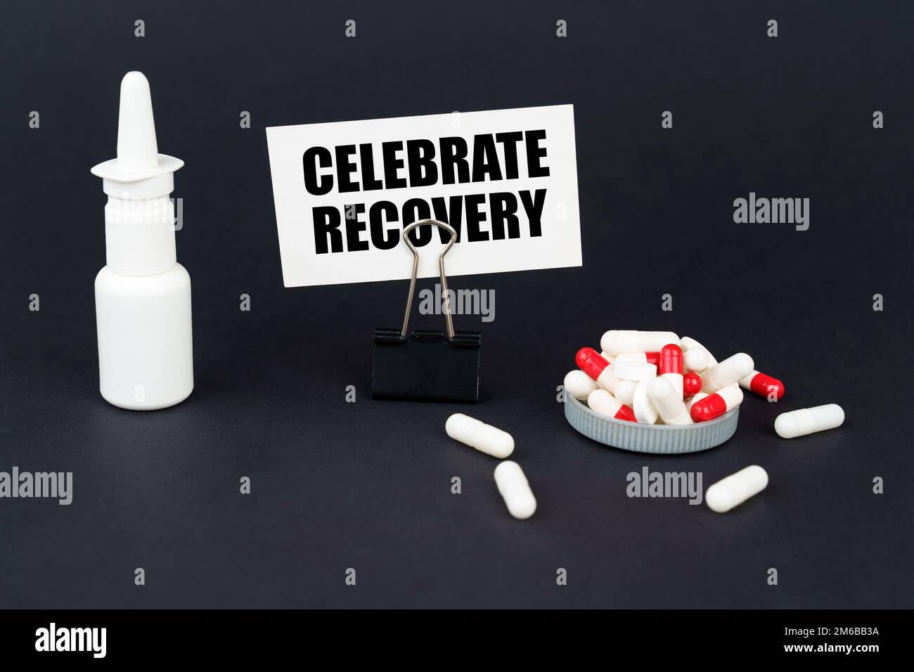 Medical concept. On the black surface of a pill, a nasal spray and a ...