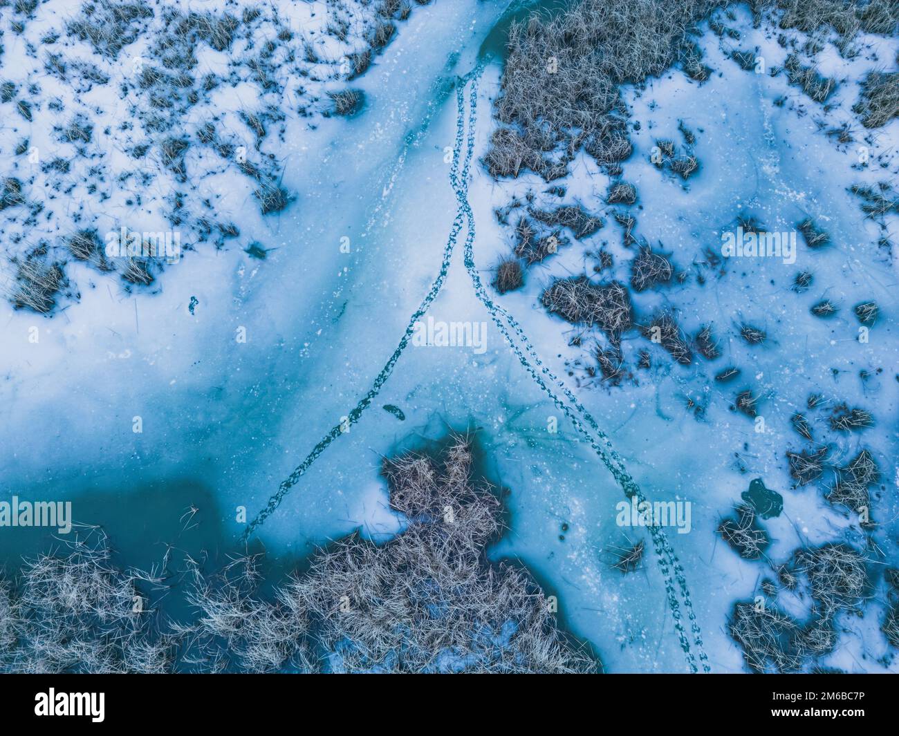 Panoramic aerial view of a frozen lake with animal footprints. Animal ...