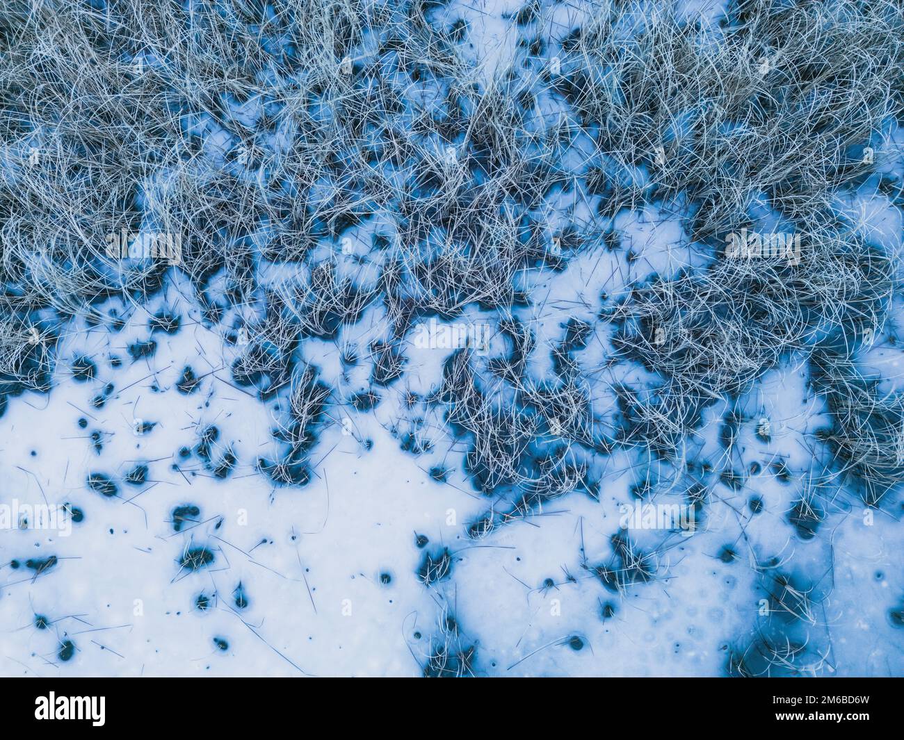 Aerial view of a frozen lake. Ice sheet background. Frozen grass on the ...