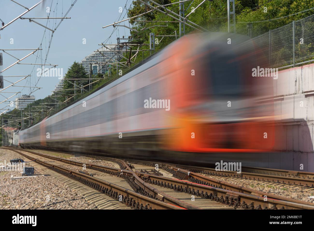 Railroad suburban passenger train passing by in motion at sunset ...