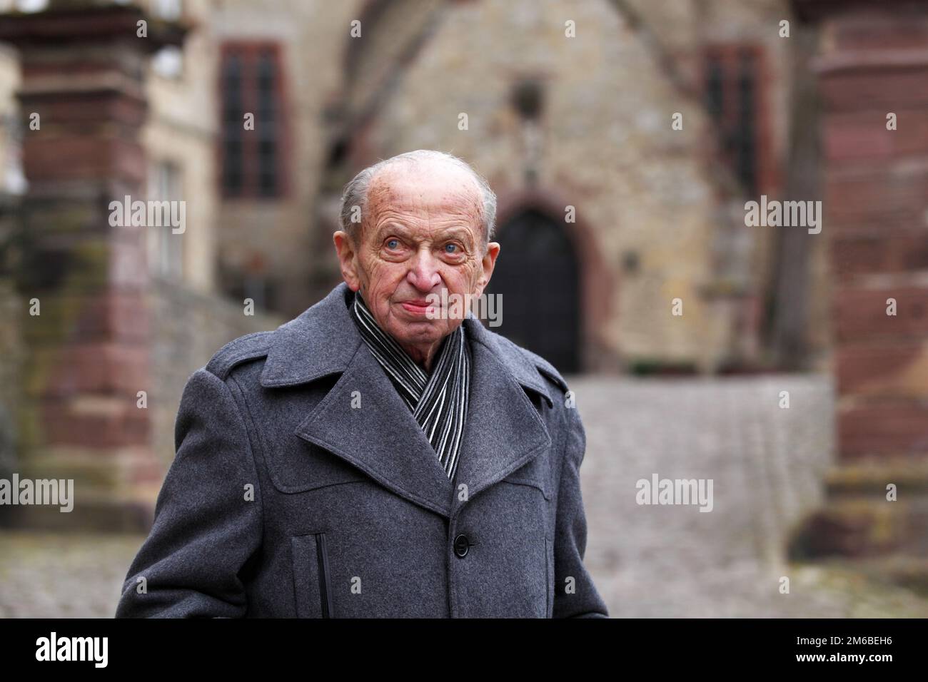 Elderly man standing in front of a church in a historic German town ...