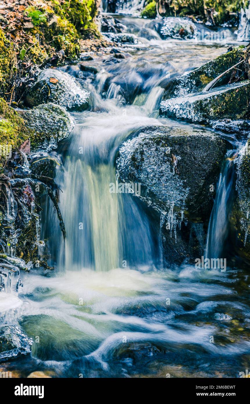 The flow of water in the spring of icicles and ice Stock Photo - Alamy