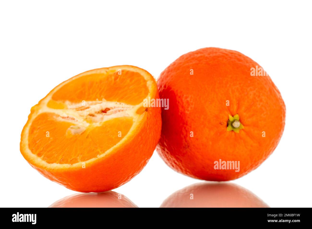 One half and one whole sweet organic tangerine, macro, isolated on ...