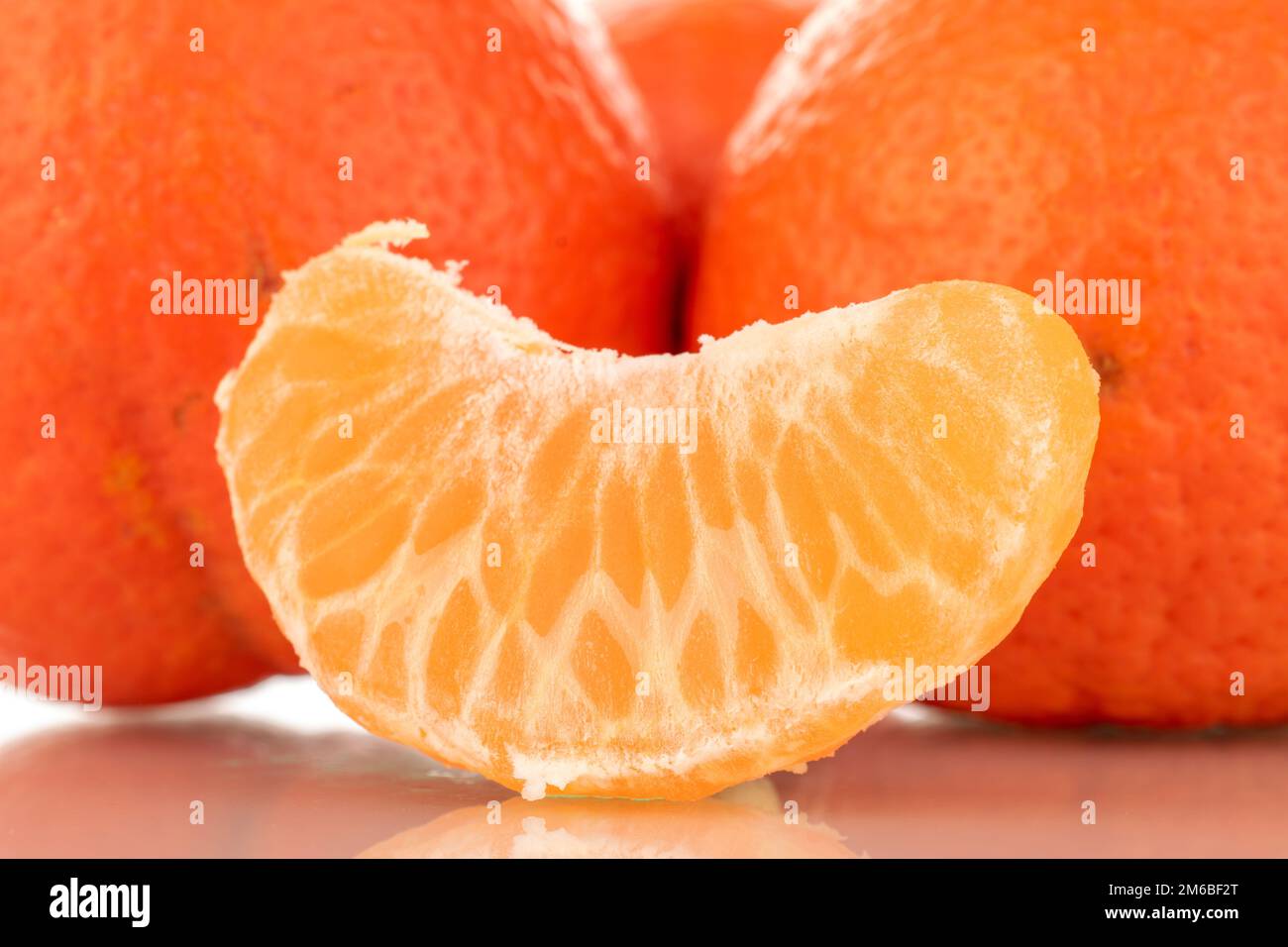 One slice and three whole sweet organic tangerines, macro, isolated on ...