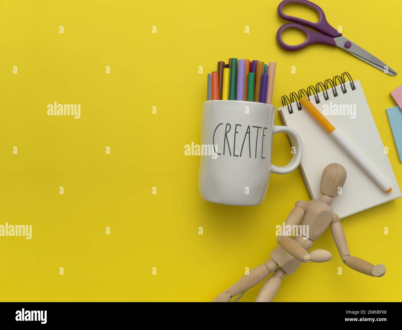 Overhead flat lay of a creative workspace with stationary against a ...