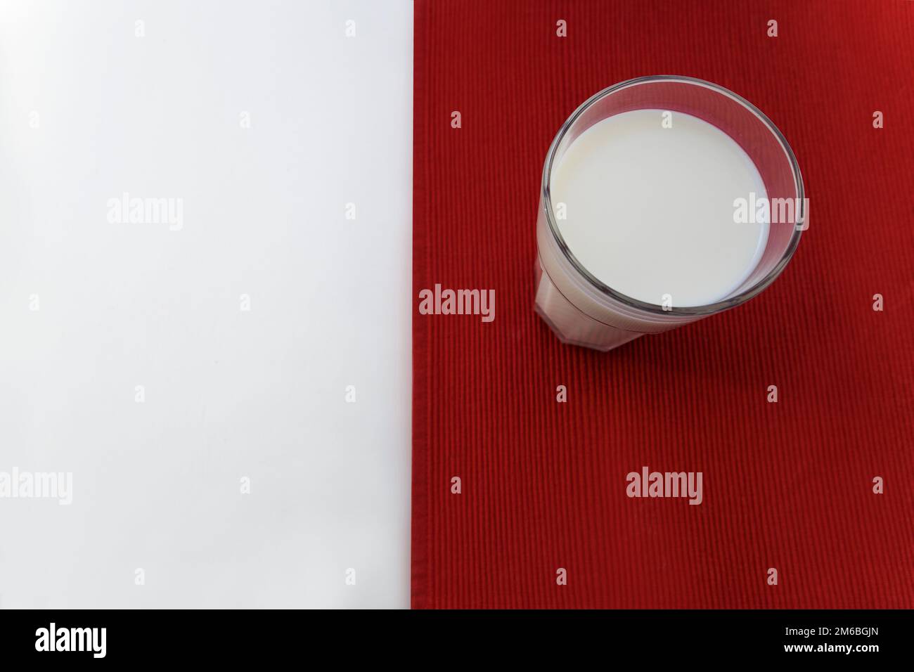 Glass with milk on a red background Stock Photo - Alamy