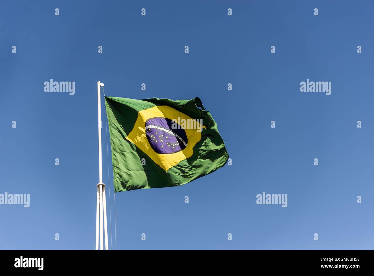 Flag of Brazil fluttering in the wind. In the center of the flag with ...