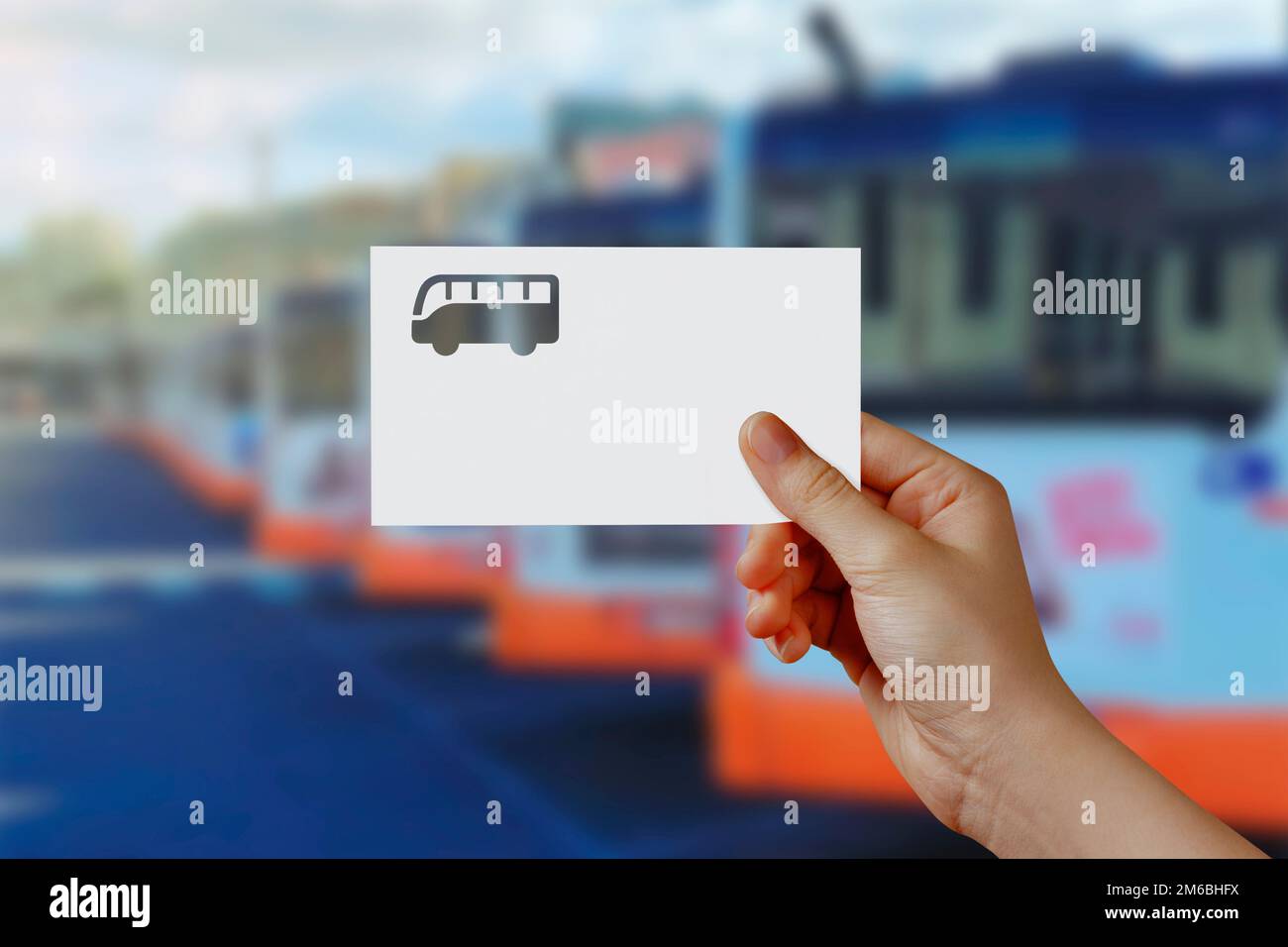 Man's hand holding bus symbol paper in bus depot. Concept of journey ...
