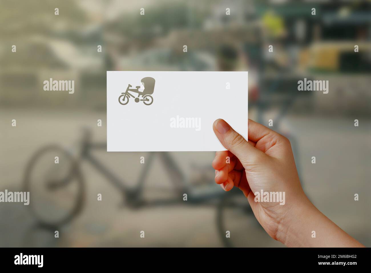 Man's hand holding Cycle Rickshaw symbol paper on road. Concept of ...