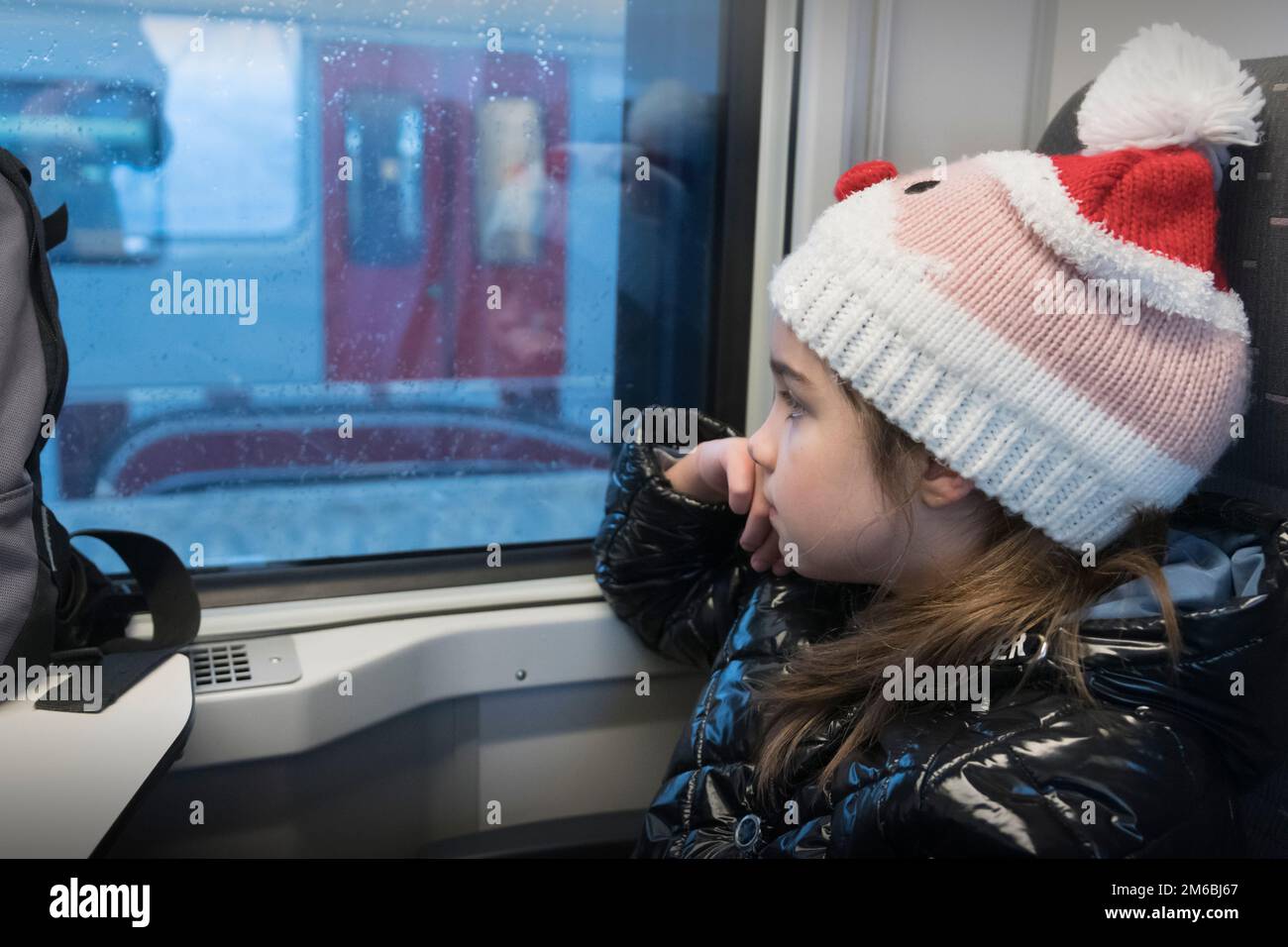 Sad girl in a train carriage looks out the window Stock Photo - Alamy