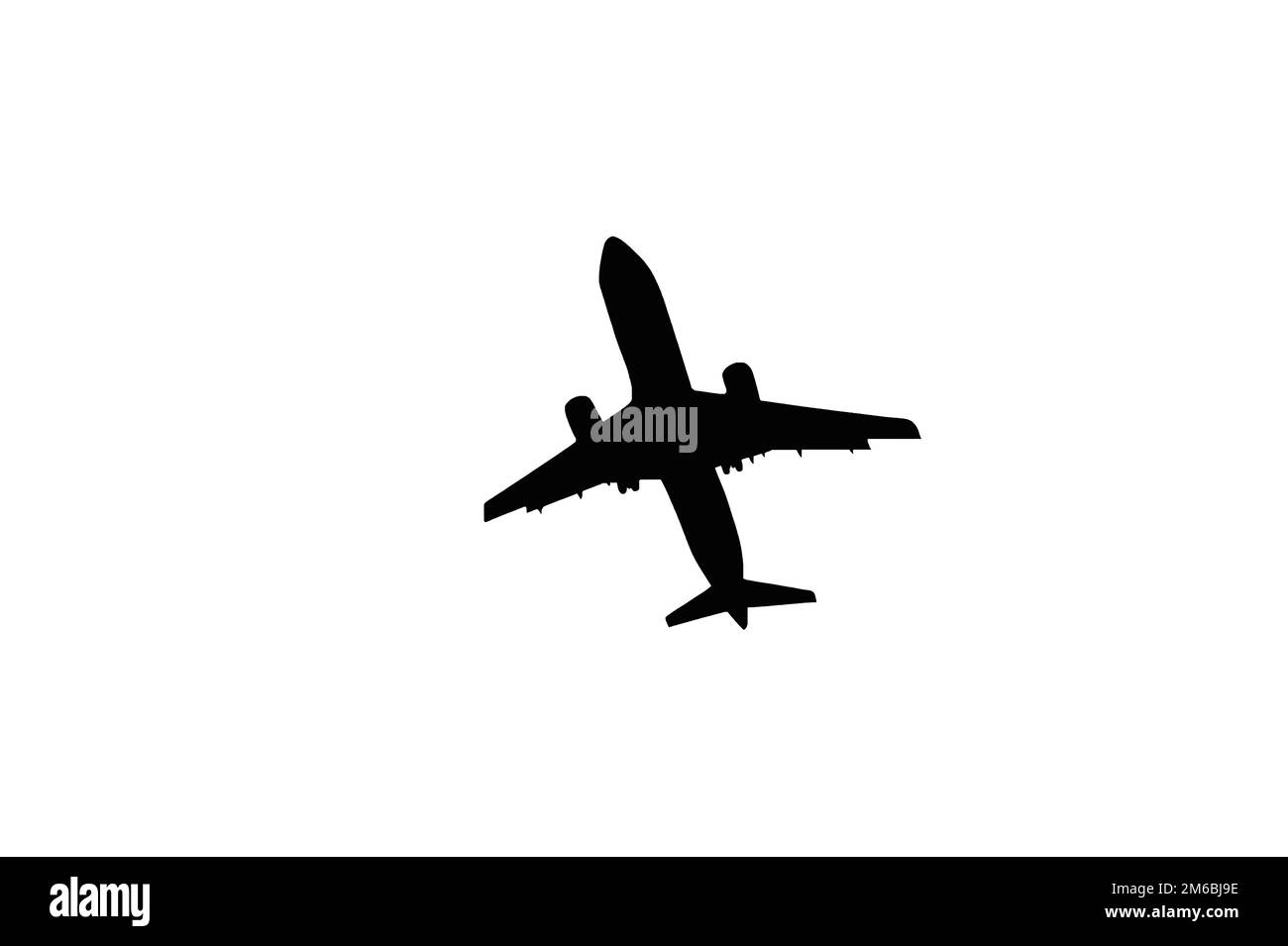 Silhouette of a passenger jet flying overhead on a plain white ...