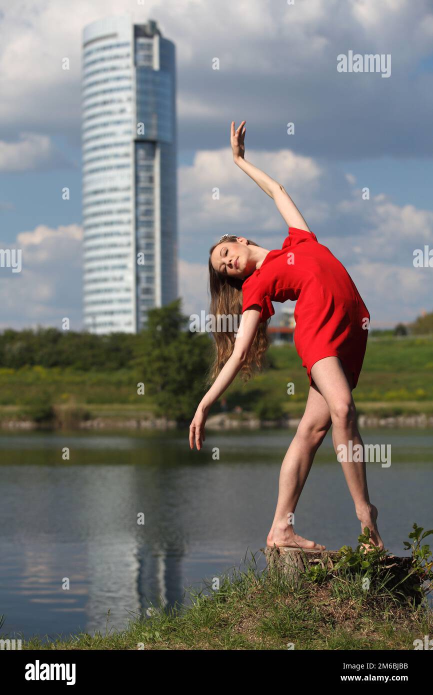 Beautiful ballerina in red dress dancing barefoot at a river Stock Photo - Alamy
