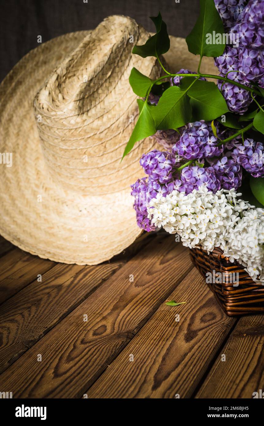 Still-life with a bouquet of lilacs and a straw hat, close-up Stock ...