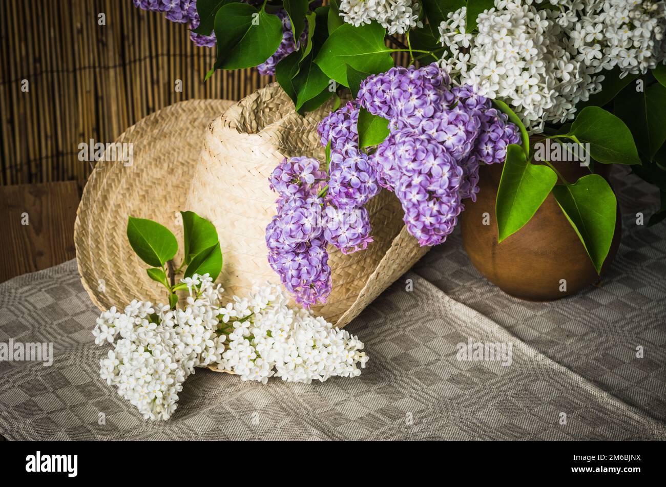 Still-life with a bouquet of lilacs and a straw hat, close-up Stock ...