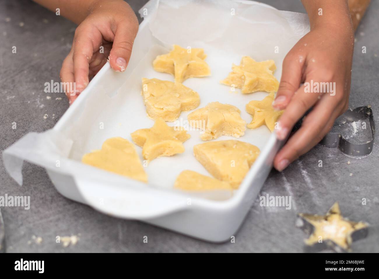 Vanilla Shortbread biscuits ready to be baked in tray, with child's ...