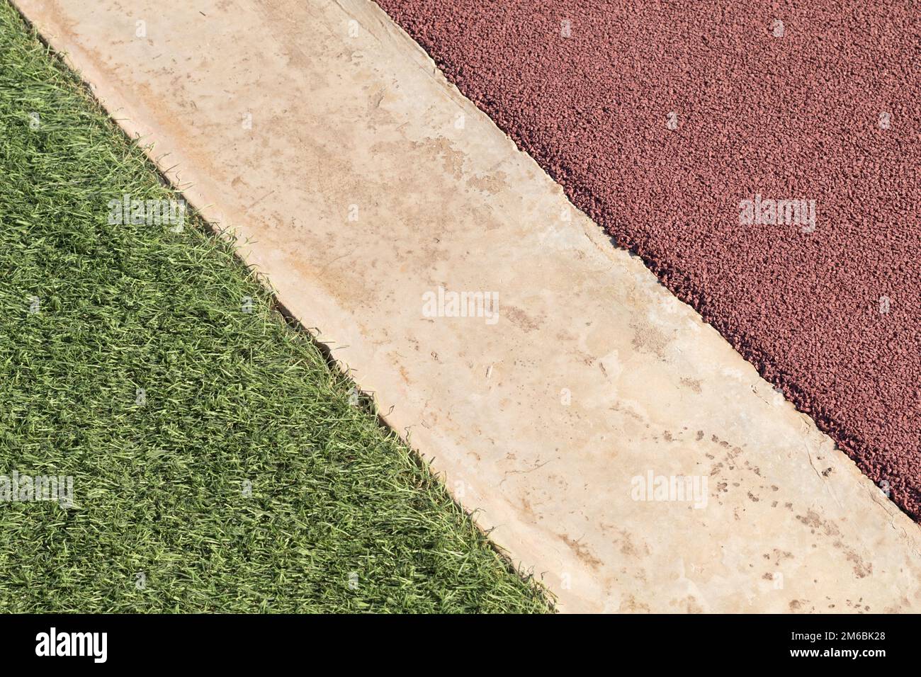 Red Rubber Wetpour playground floor surface next to concrete and ...