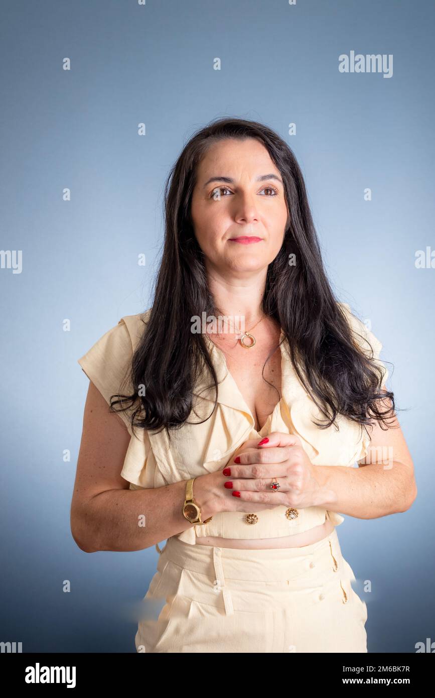 Young beautiful woman with hands together, confident, cheerful ...