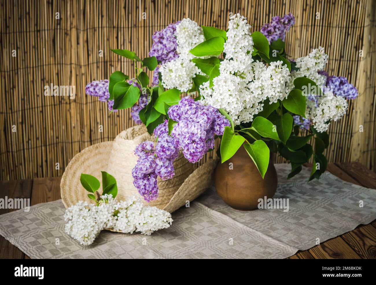 Still-life with a bouquet of lilacs and a straw hat, close-up Stock ...
