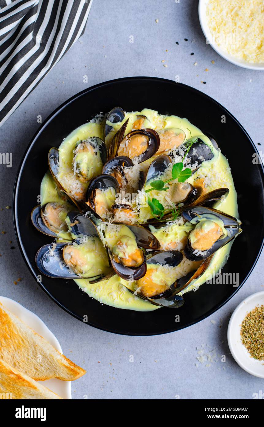 Freshly cooked mussles in wine and creamy sauce in a plate on a table ...