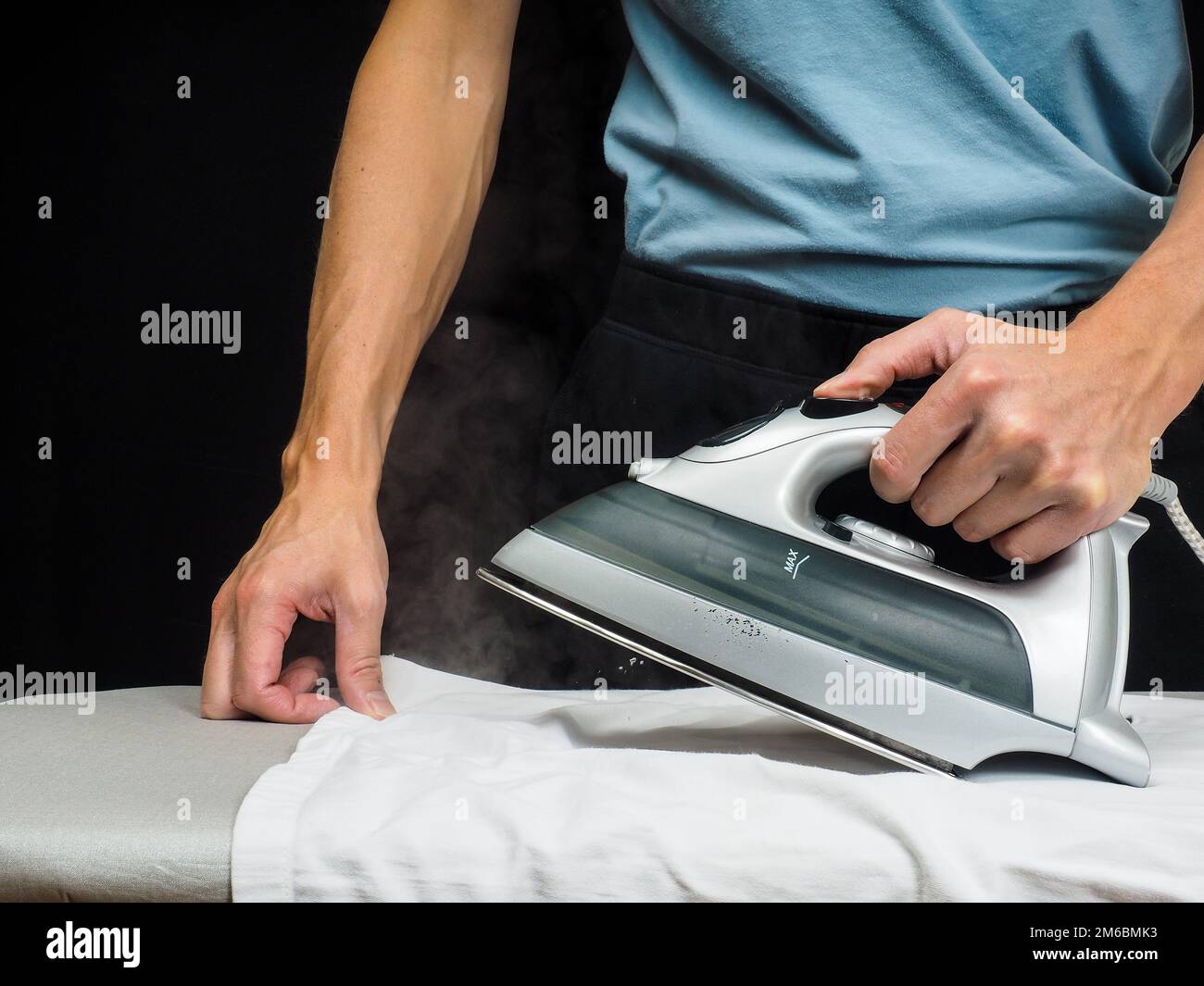 Male hand ironing white hi-res stock photography and images - Alamy