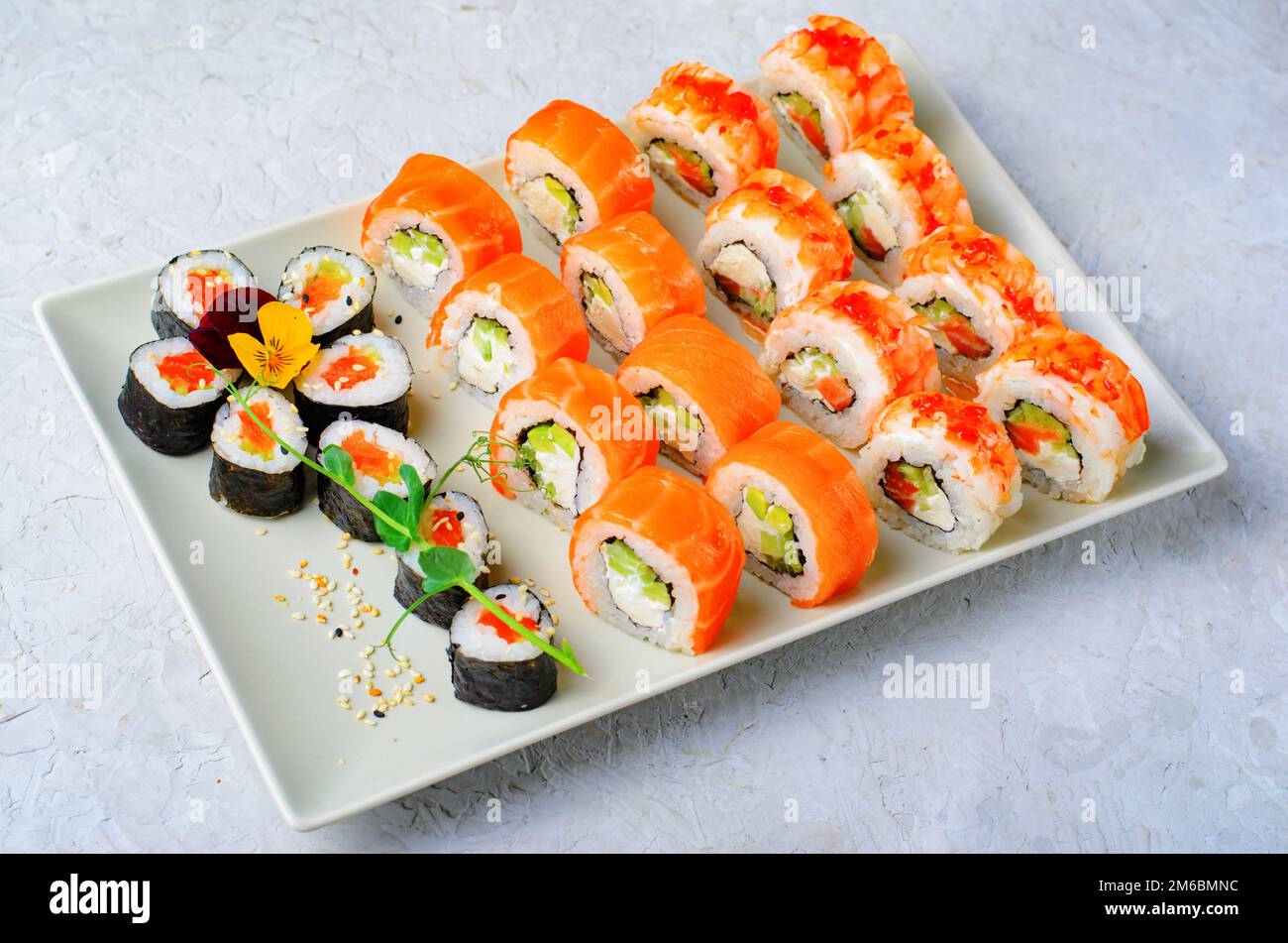 Sushi rolls set with salmon and shrimp on light blue background, Flower ...