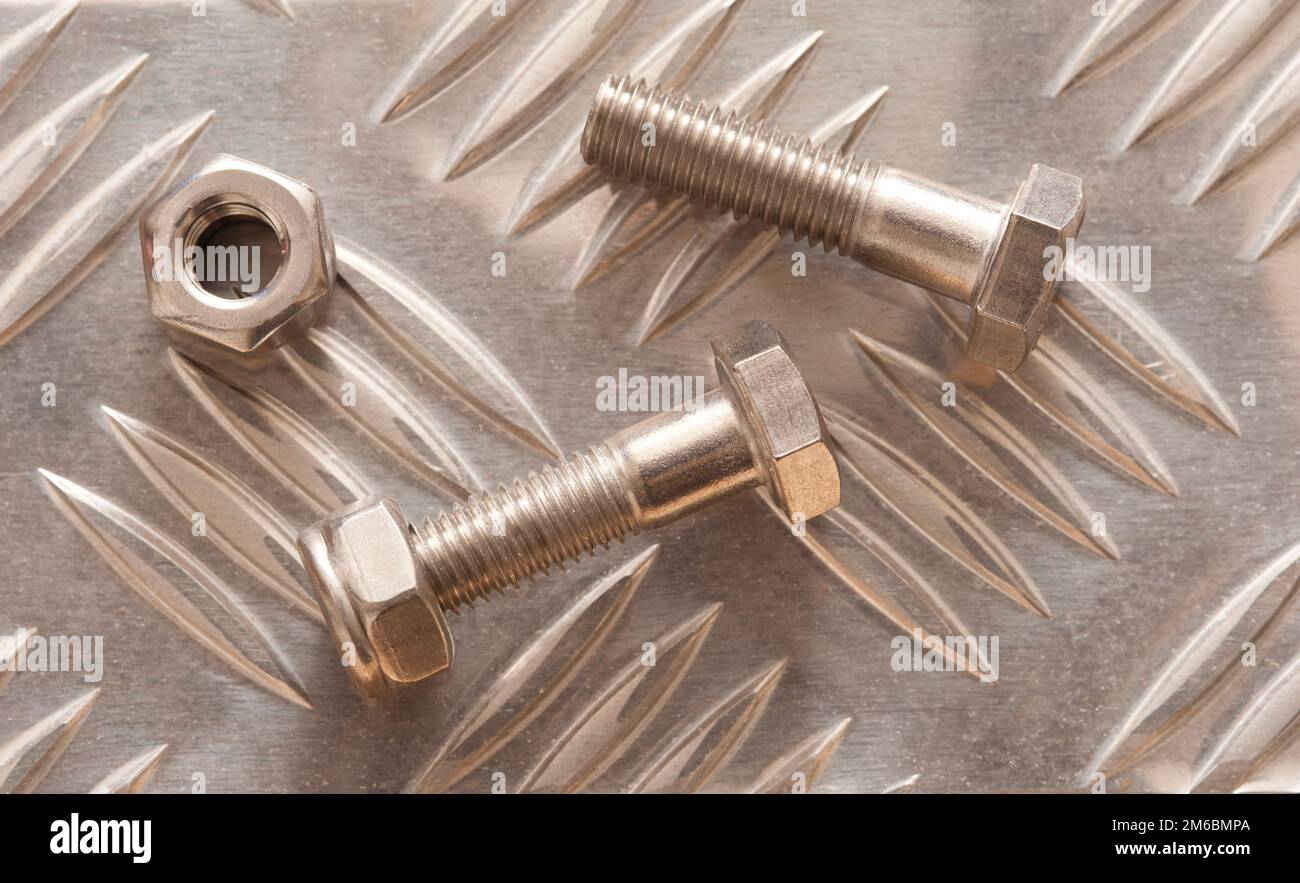 Embossed metal sheet with nuts and bolt Stock Photo - Alamy