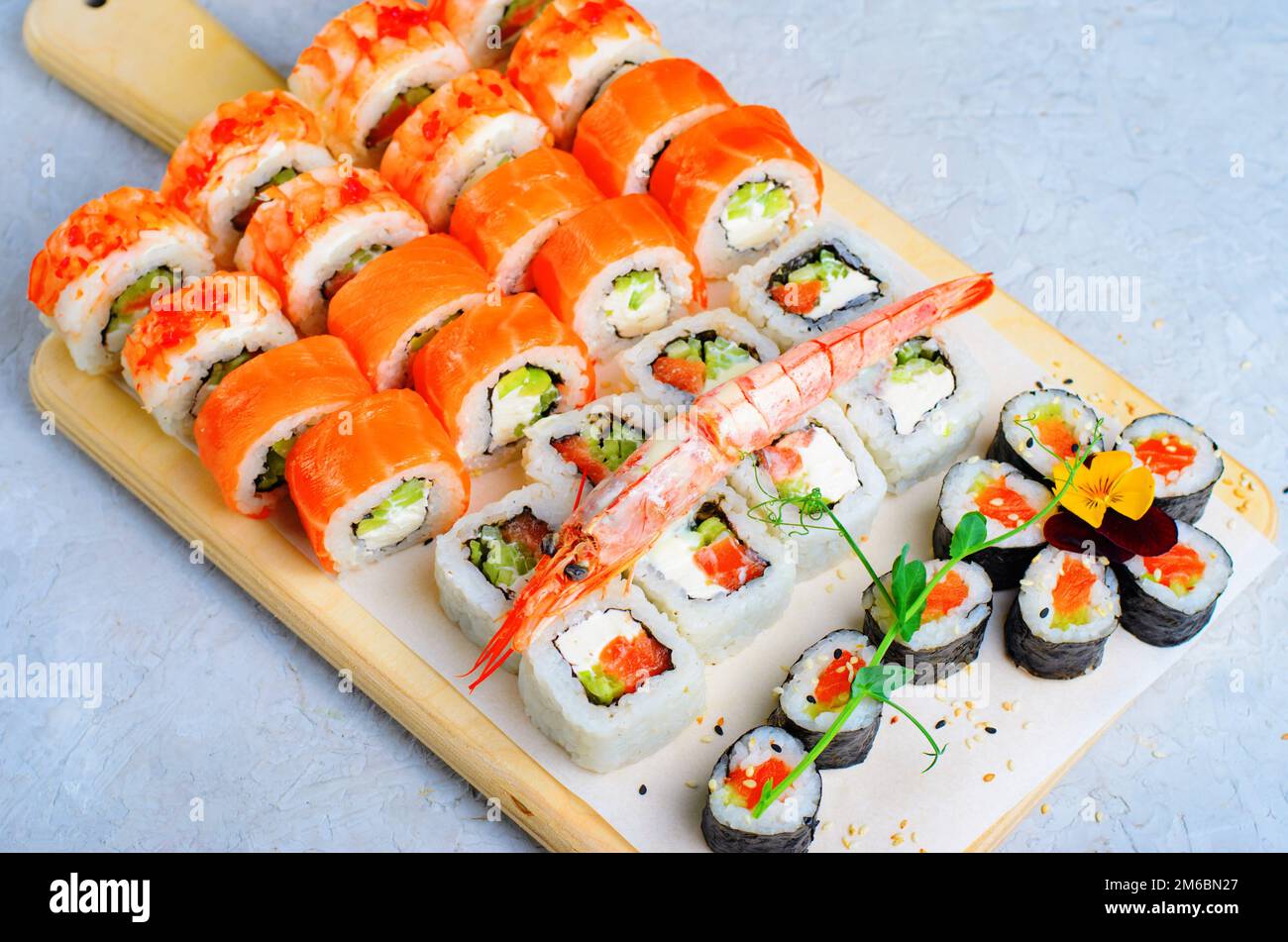 Sushi rolls set with salmon and shrimp on light blue background, Flower ...